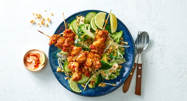 Kipdij saté geserveerd met Aziatische spicy broccolisalade en pinda’s